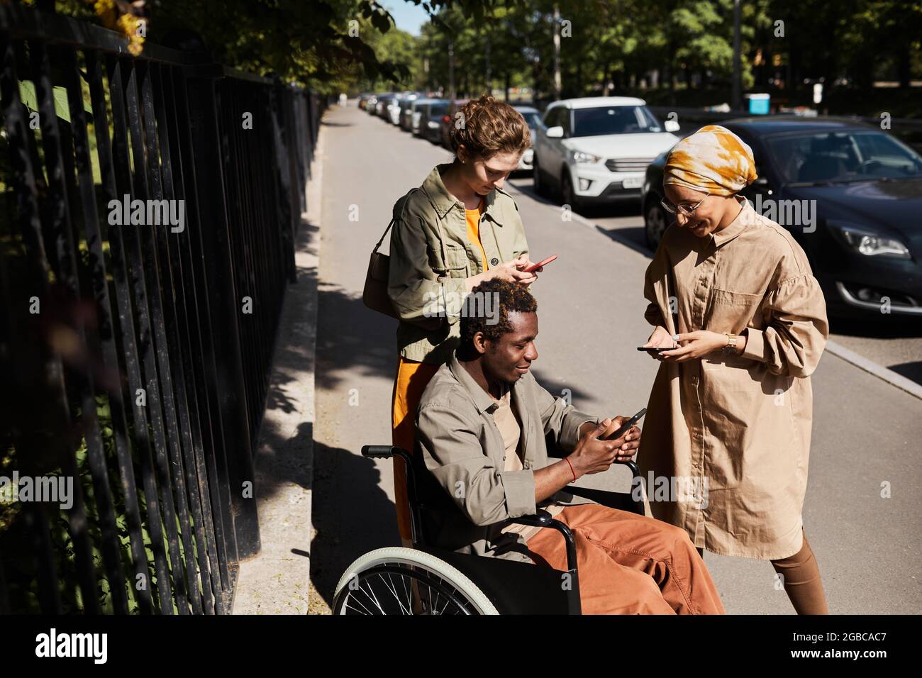 Group of young multi-ethnic friends with disabled man in wheelchair ...