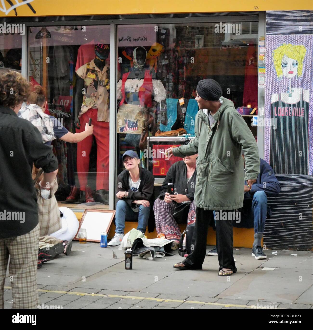 People outside a shop drinking and dancing in Brick Lane Market ...