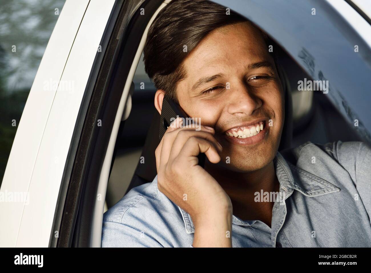 Indian man talking on phone while driving Stock Photo - Alamy