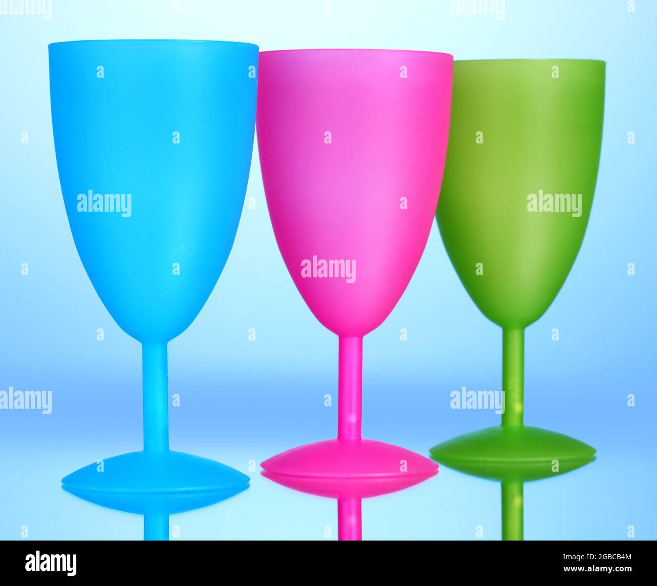 Bright plastic goblets on blue background Stock Photo - Alamy