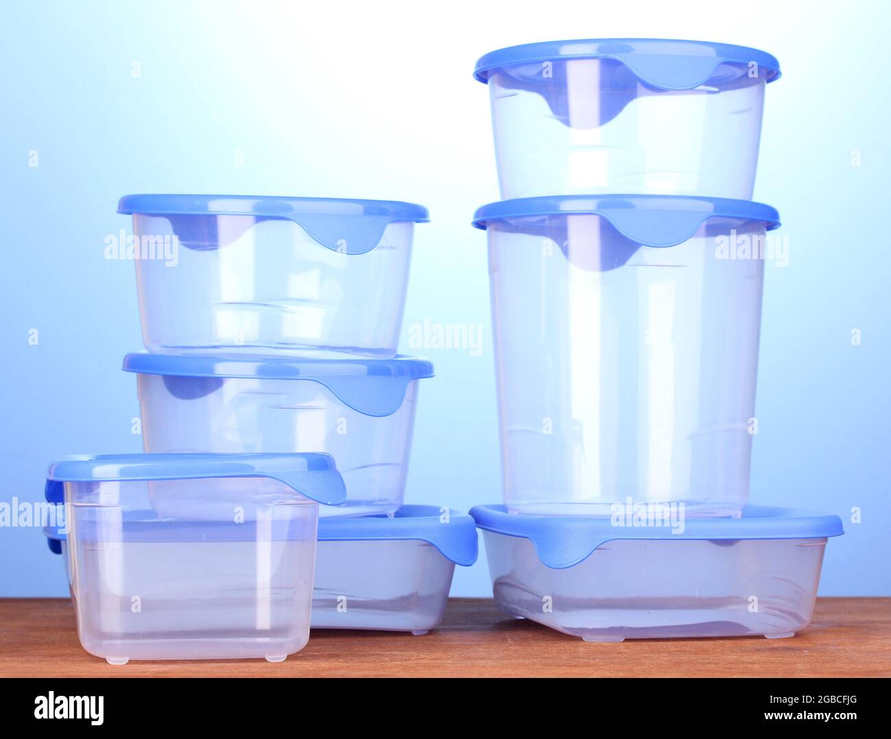 Plastic containers for food on wooden table on blue background Stock ...
