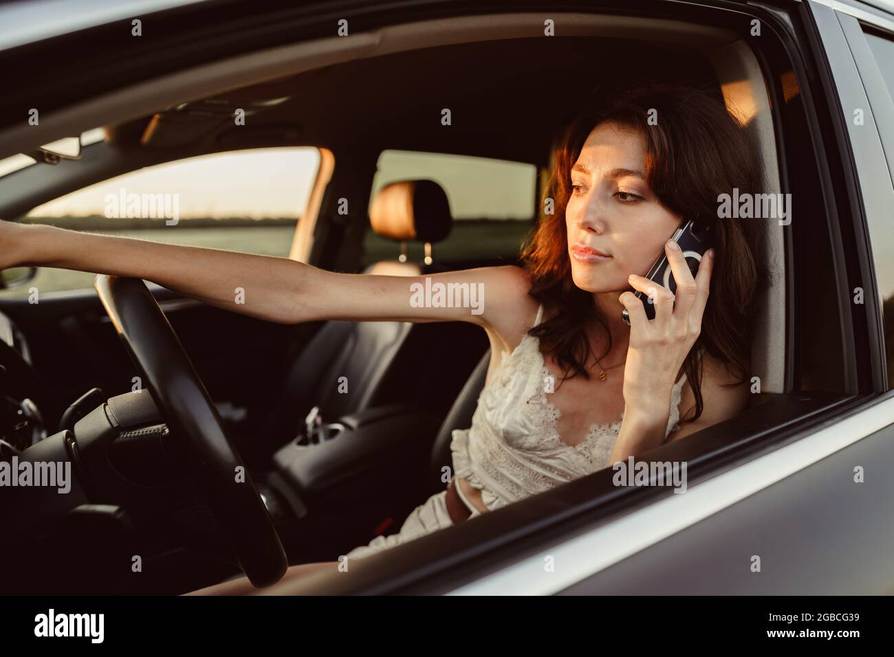 Portrait of woman talking on mobile phone while driving her car Stock ...