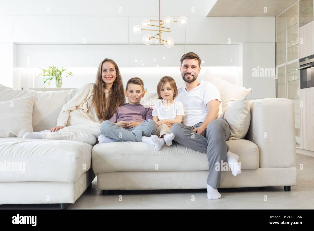Family portrait of young parents with their two children at home, white ...
