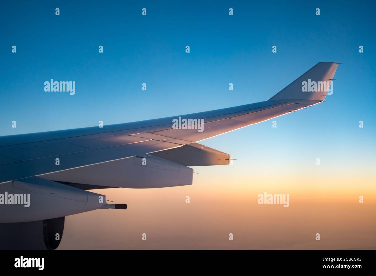 Airplane wing during flight at sunset Stock Photo - Alamy