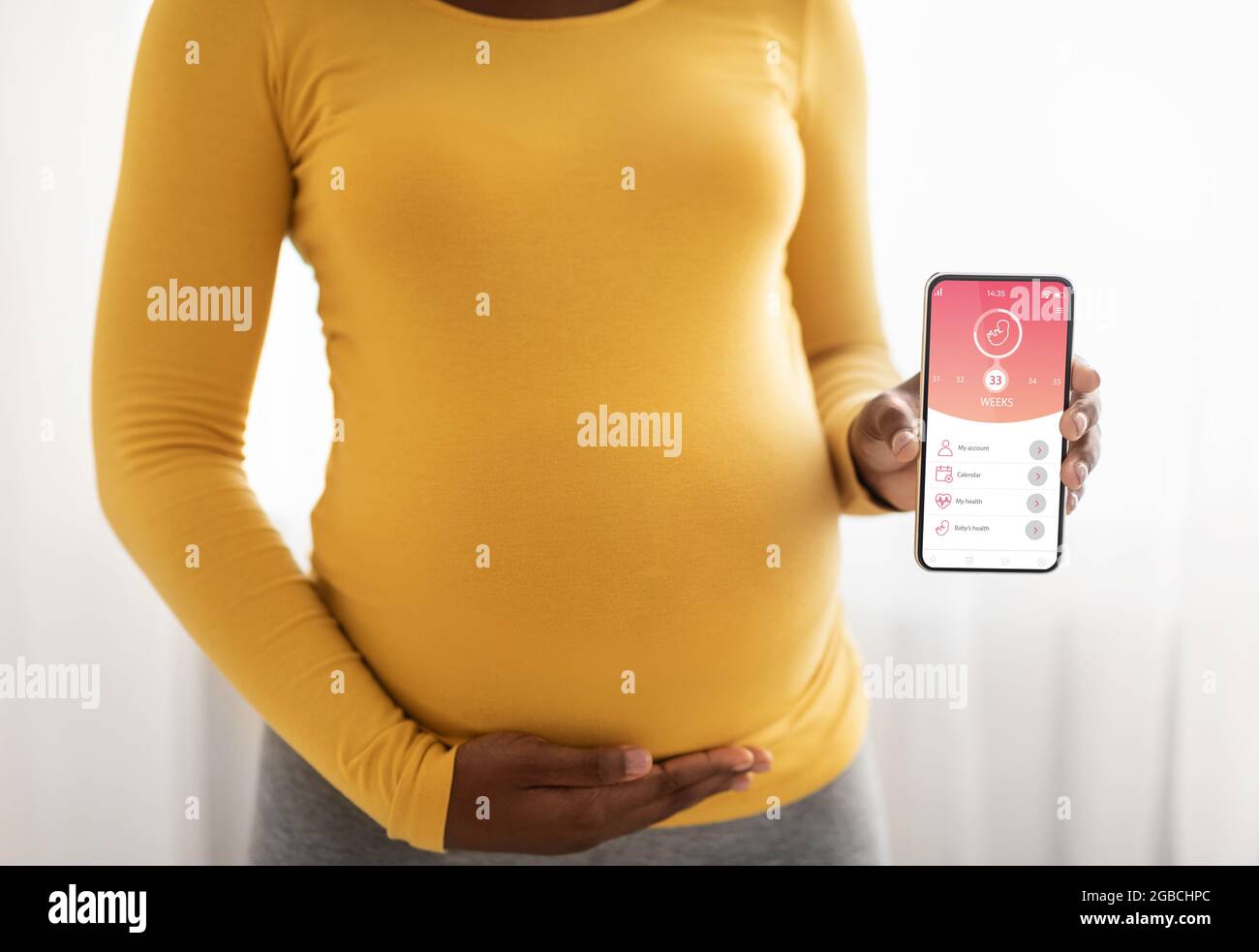 Pregnant woman showing mobile application for pregnancy Stock Photo - Alamy
