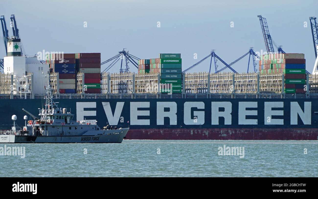 A UK Border Force boat passes the container ship Ever Given, chartered ...