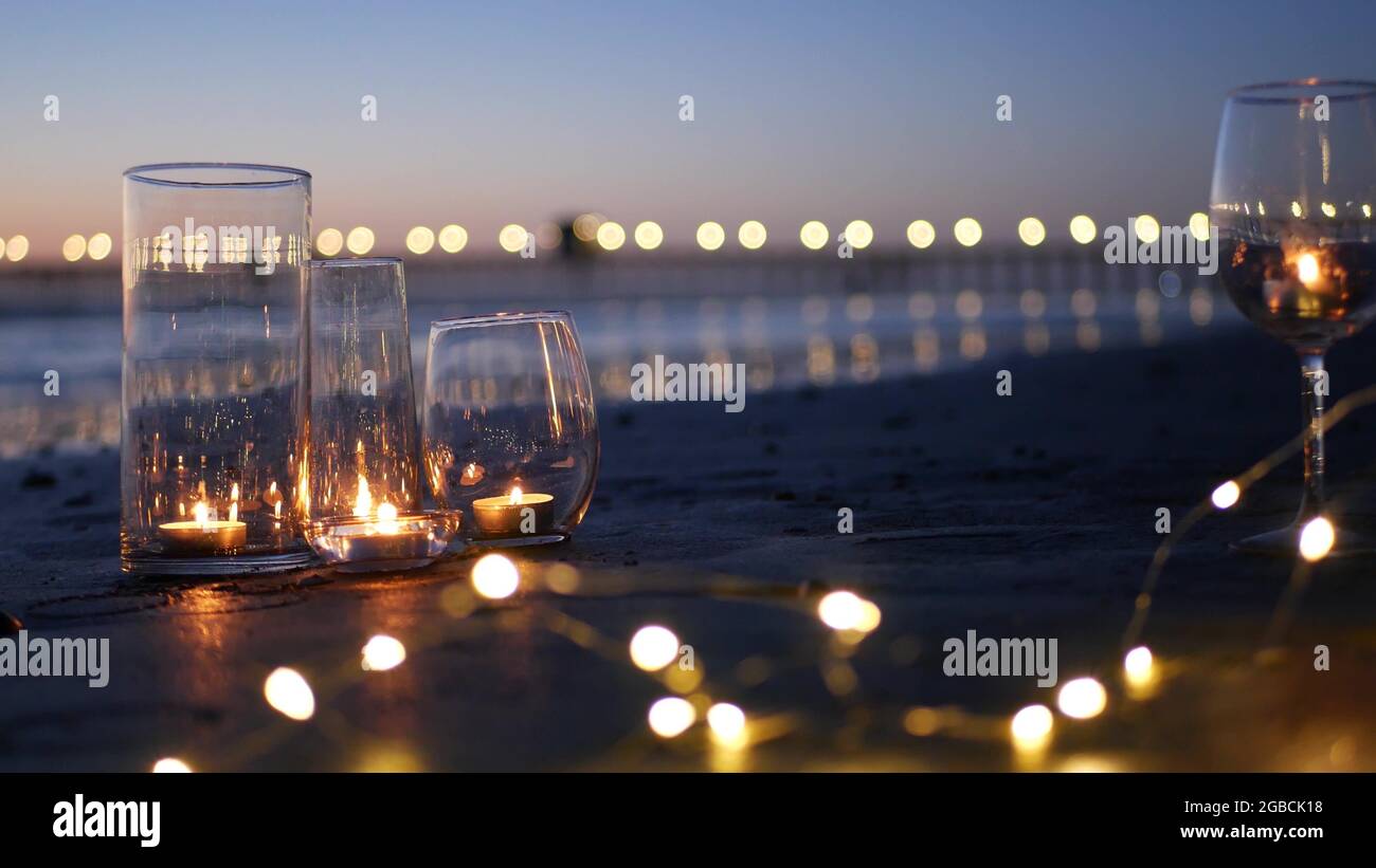 Candle flame lights in glass, romantic beach date, California ocean ...
