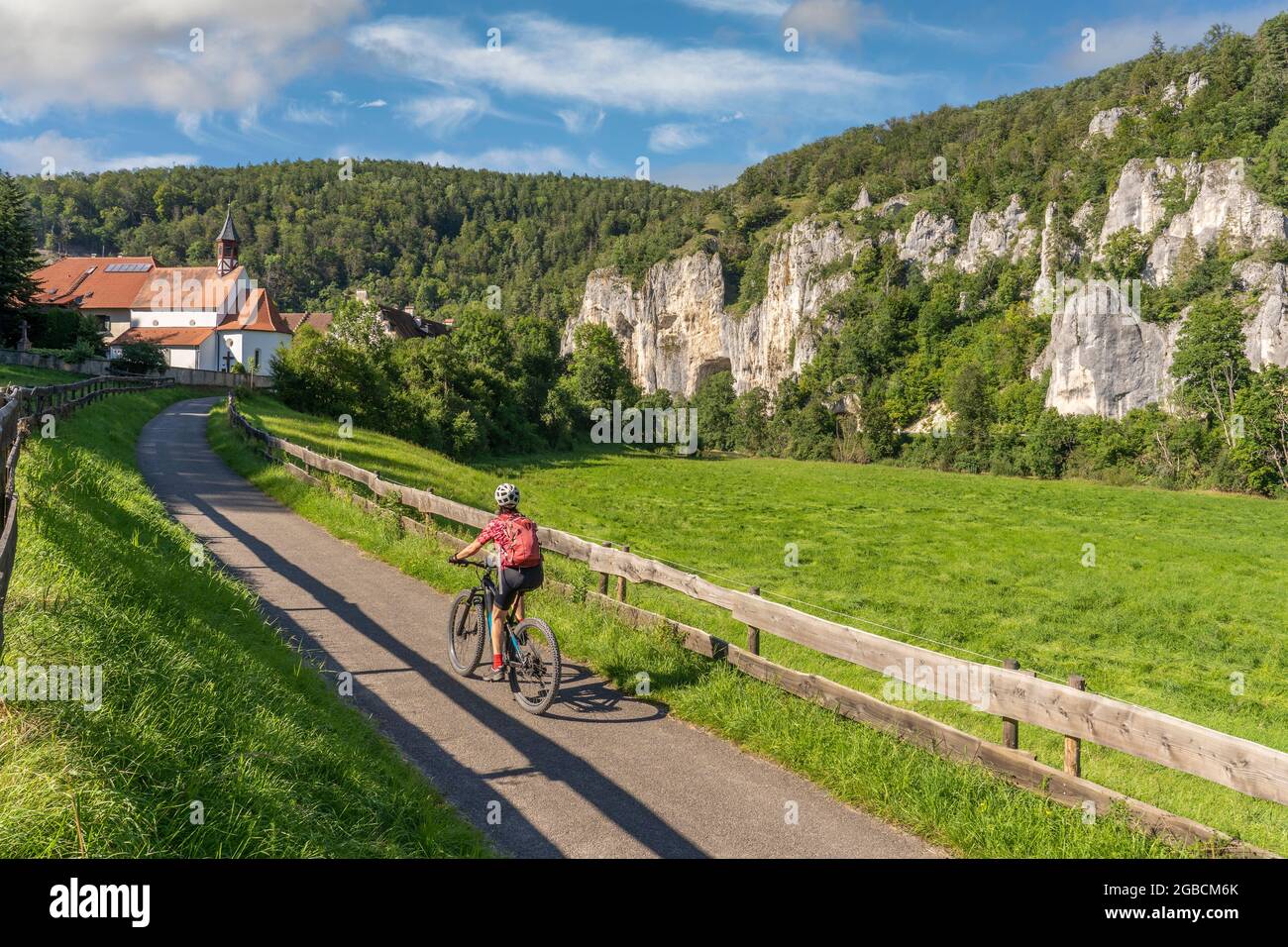 beautiful active senior woman cycling with her electric mountain bike in the rocky Upper Danube ...