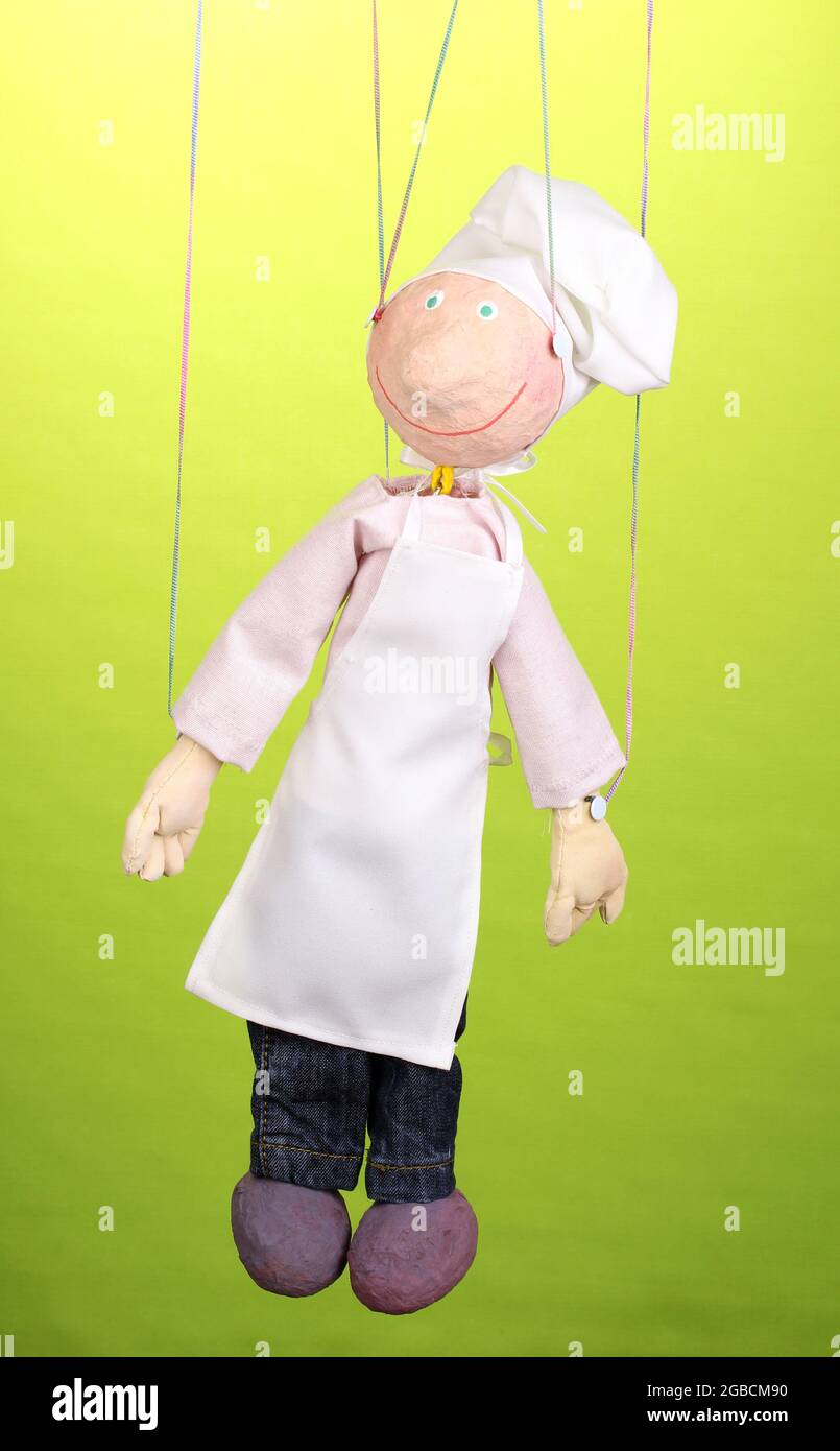 Wooden puppet as cook on green background Stock Photo - Alamy