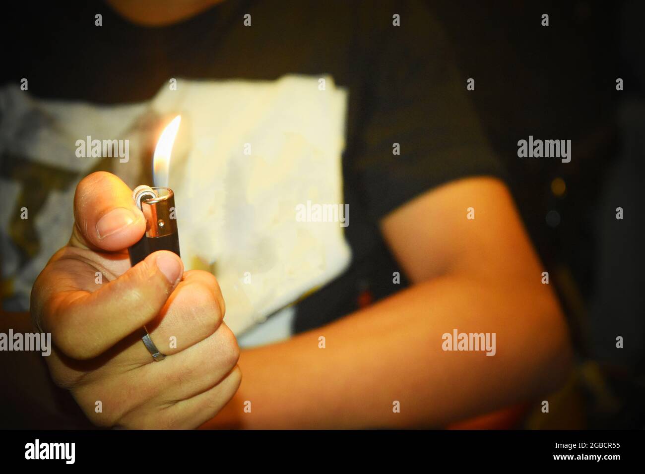 The man holding lighter in the dark Stock Photo - Alamy