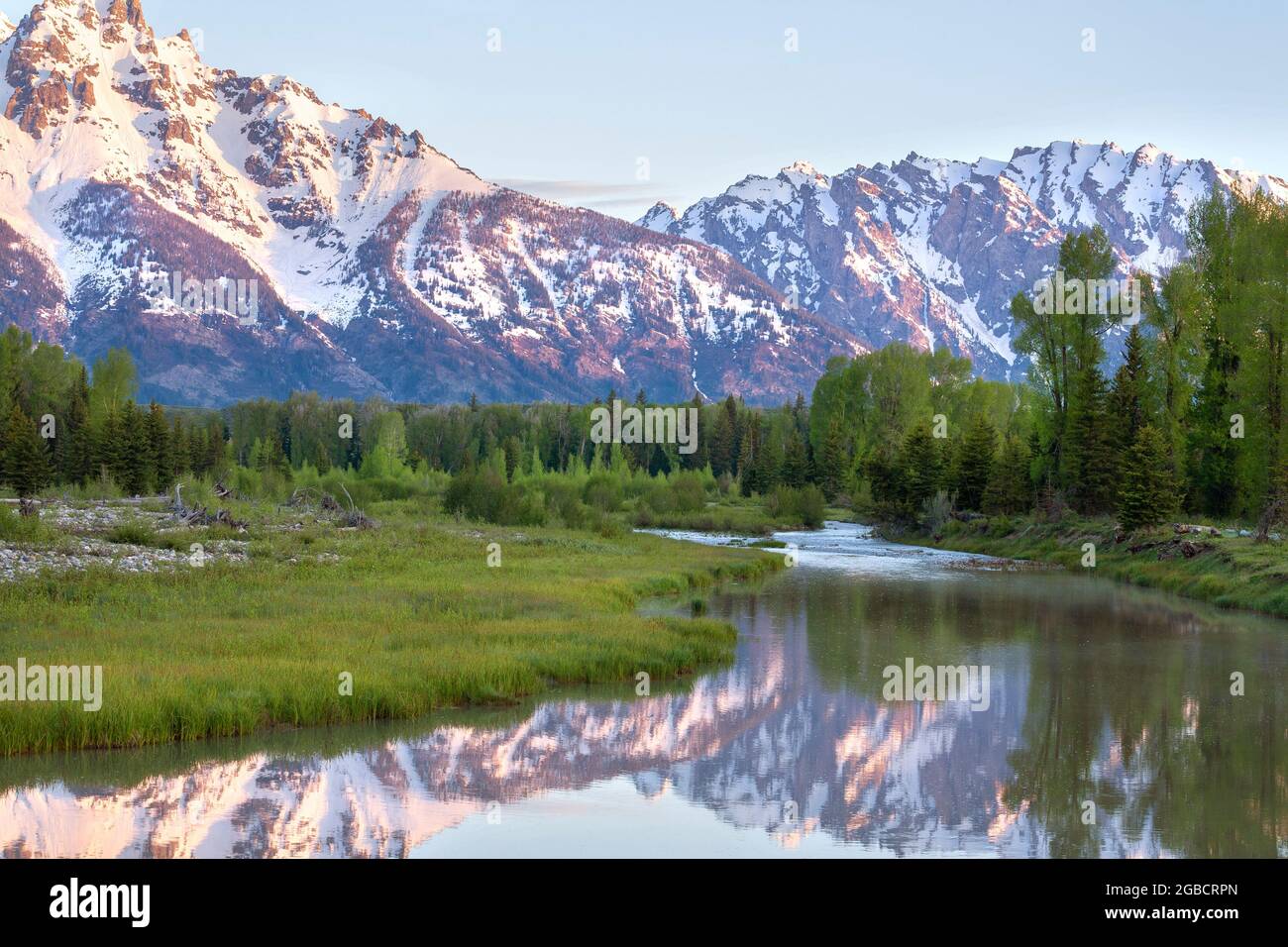 Grand Teton mountains above grassy valley and Snake River in early ...