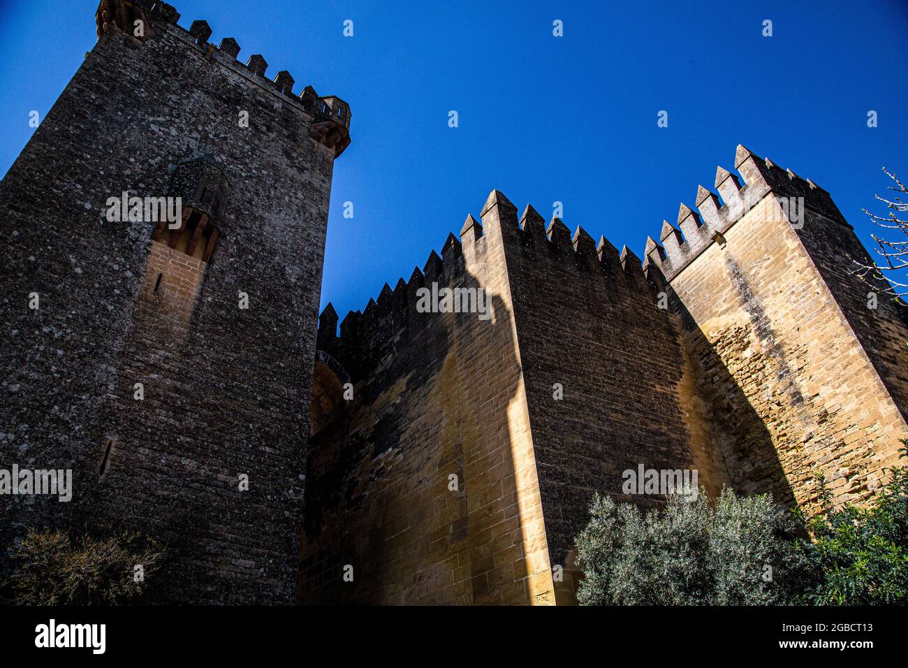 Stone walls and large square towers with defensive walkways at the top ...