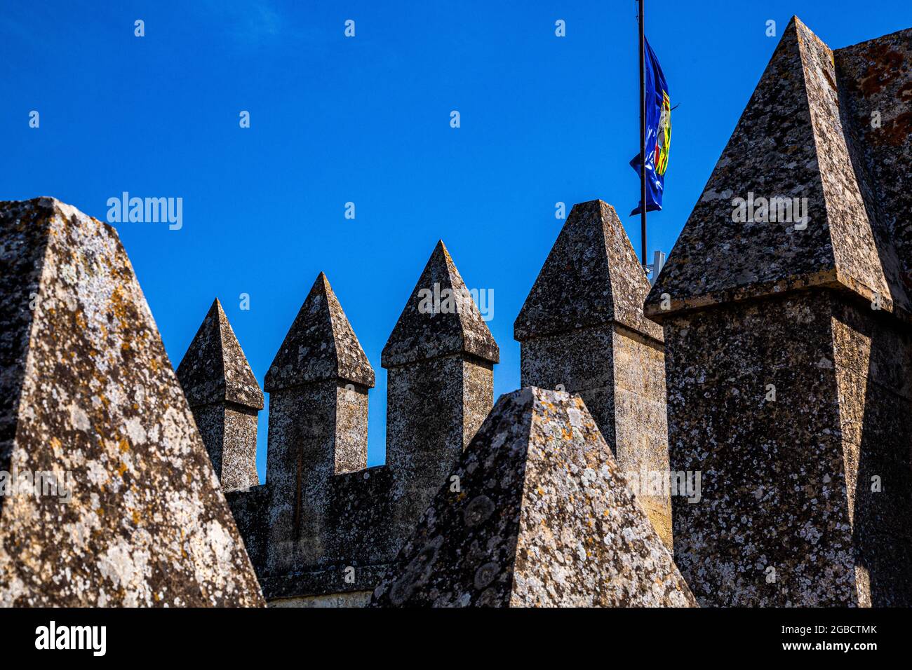 Stone walls and large square towers with defensive walkways at the top ...