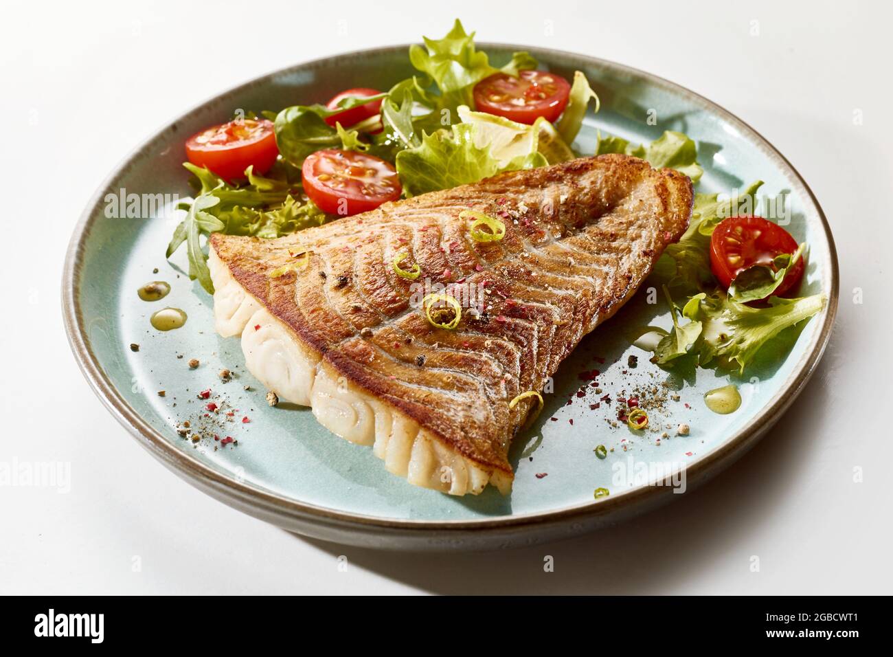 Delicious fried pollack fish steak served on blue plate with fresh ...