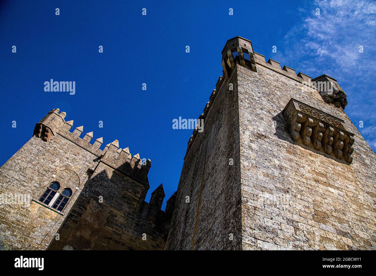 Stone walls and large square towers with defensive walkways at the top ...