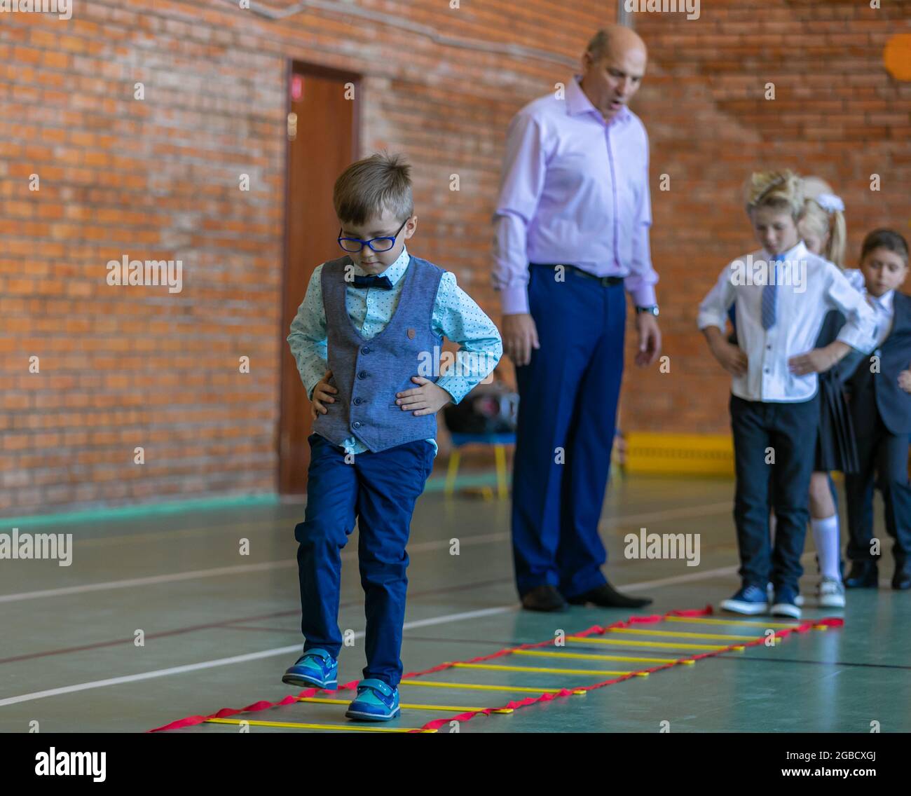 First graders in their first physical education class at the gym. The ...