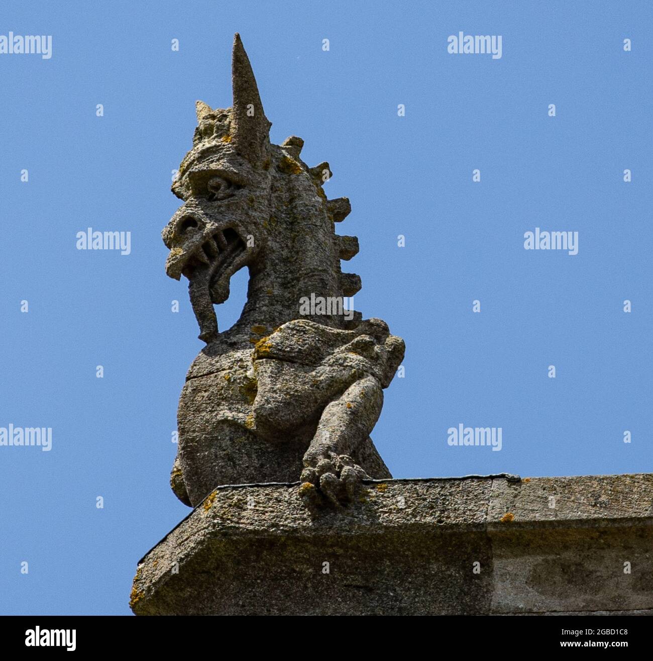 Close up of a Gargoyle Scary Stone Statue at top of building with clear ...