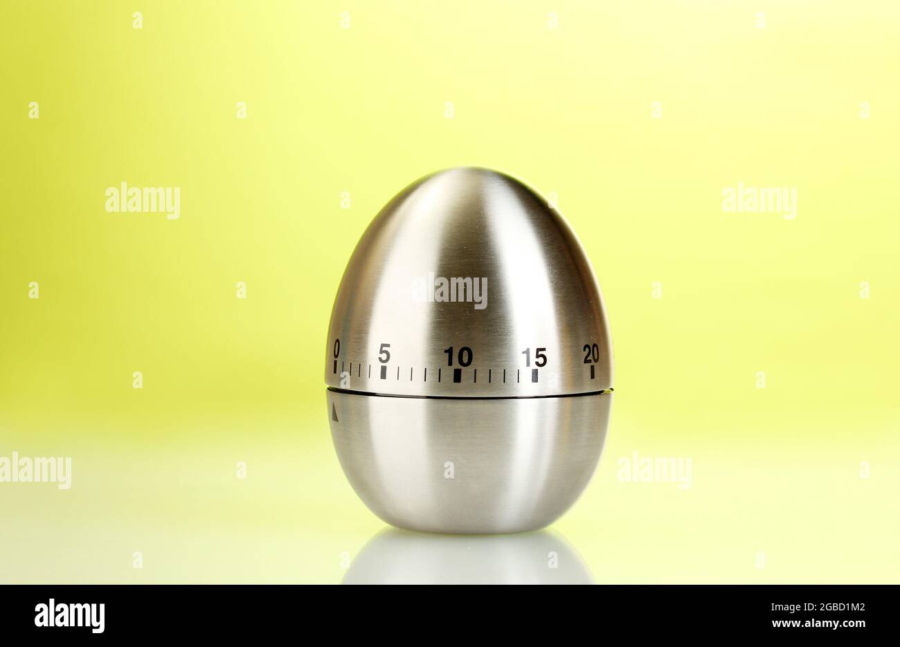 metal kitchen egg timer on a green background Stock Photo - Alamy