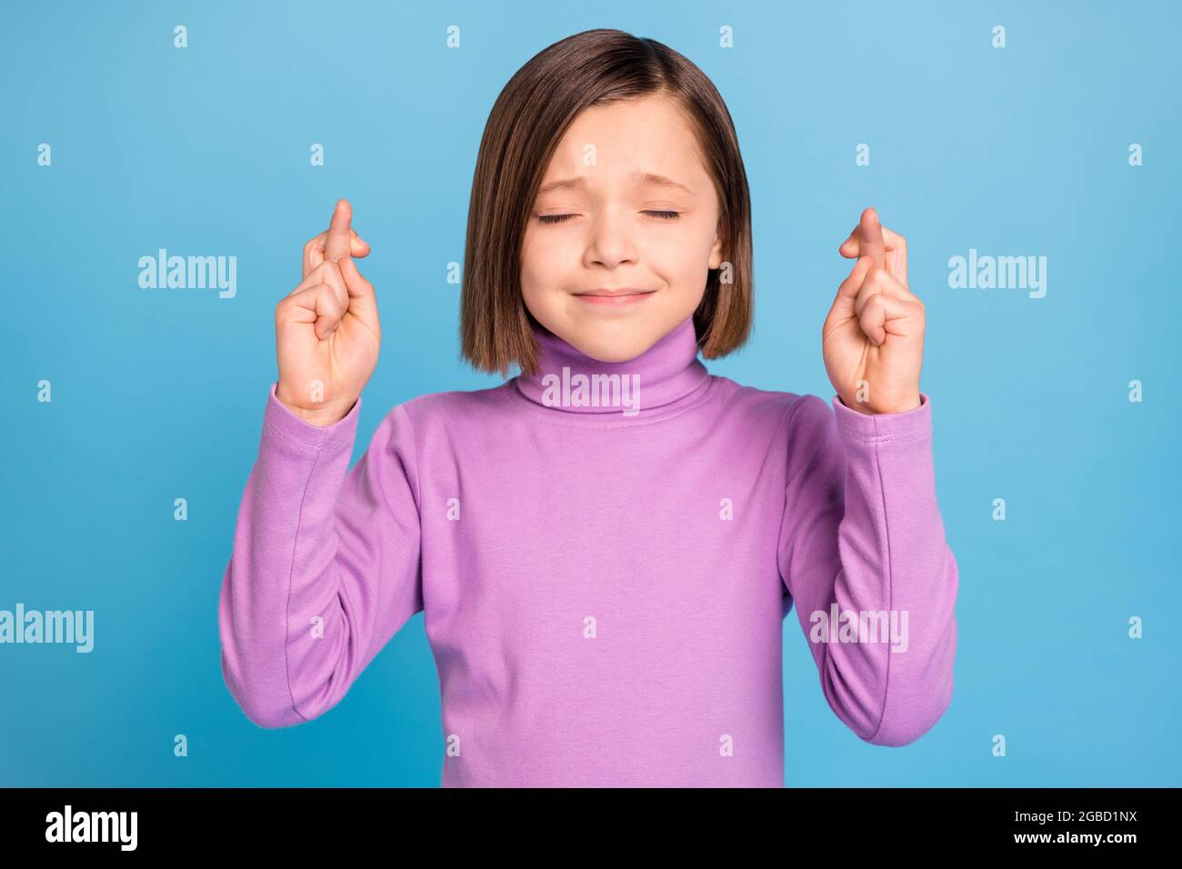 Photo portrait little girl hoping for luck with crossed fingers ...