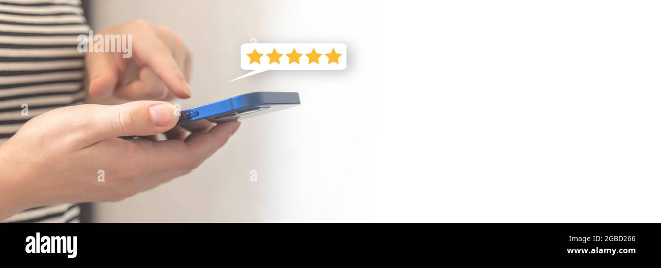 Woman hand pressing on smartphone screen with gold five star rating ...