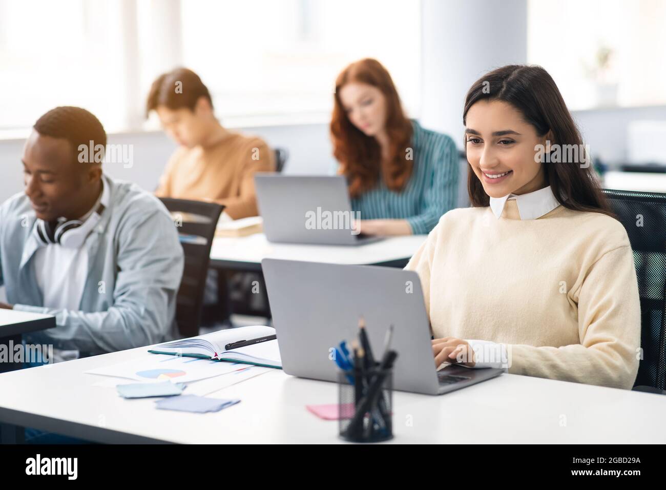 Group of international people using laptops in classroom Stock Photo ...