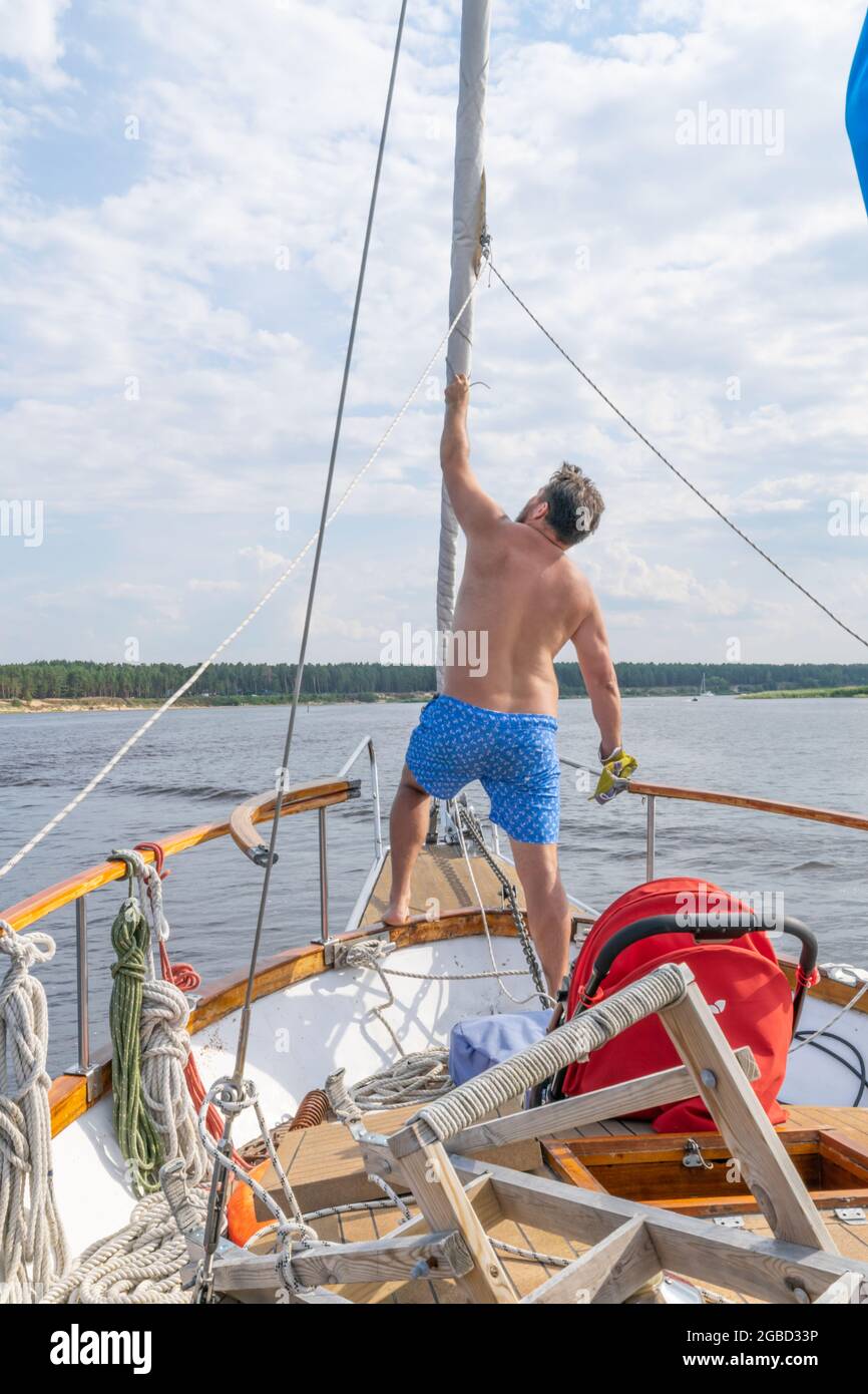 Man yachtsman sailor pulling on rope to sail out, sea holiday Stock ...