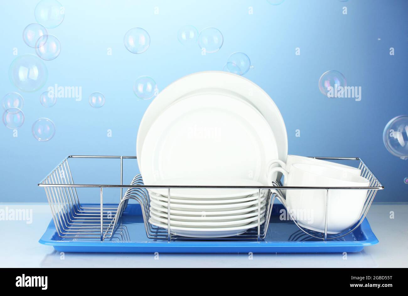 clean dishes on stand on blue background Stock Photo - Alamy