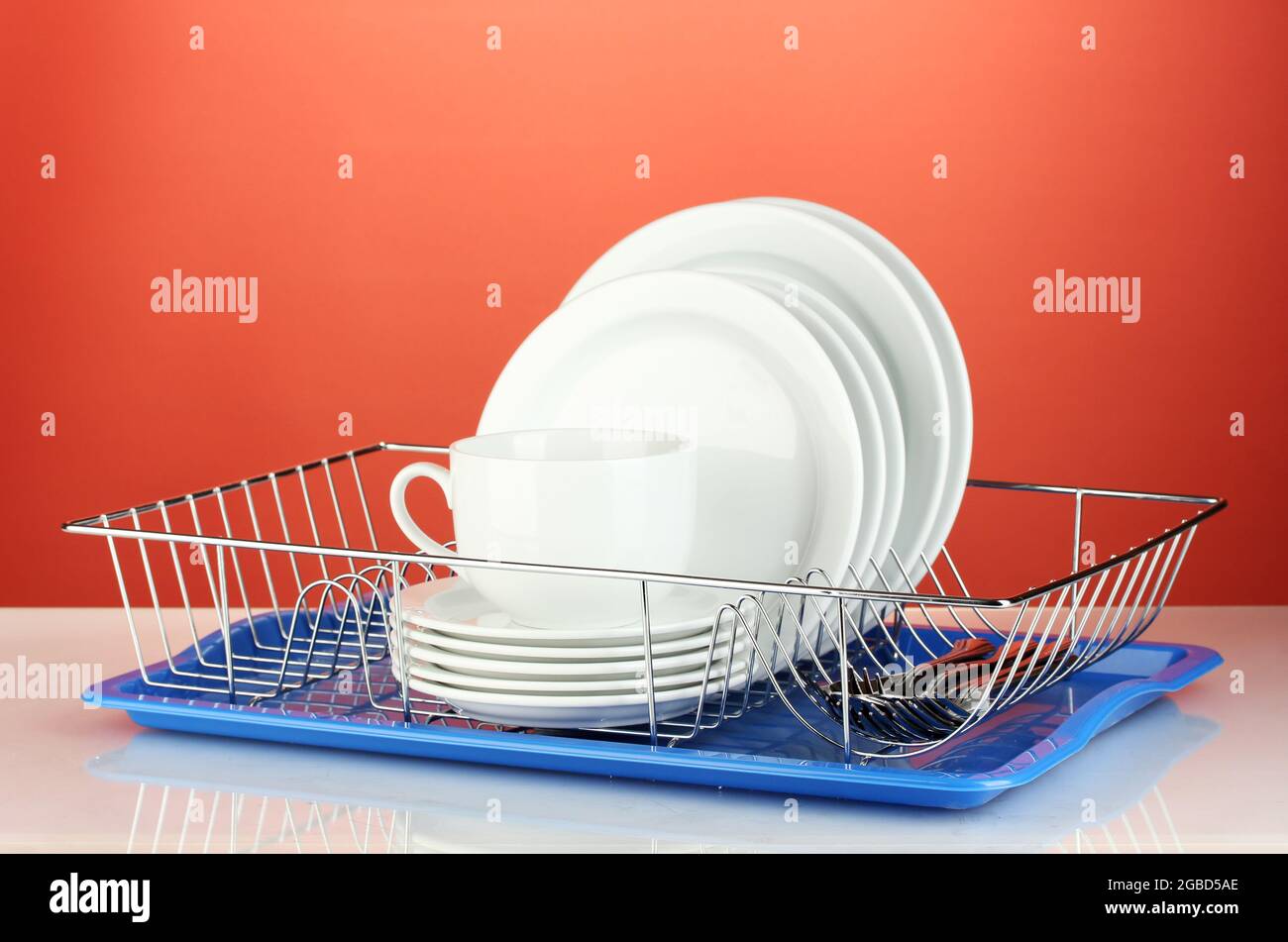 clean dishes on stand on red background Stock Photo - Alamy