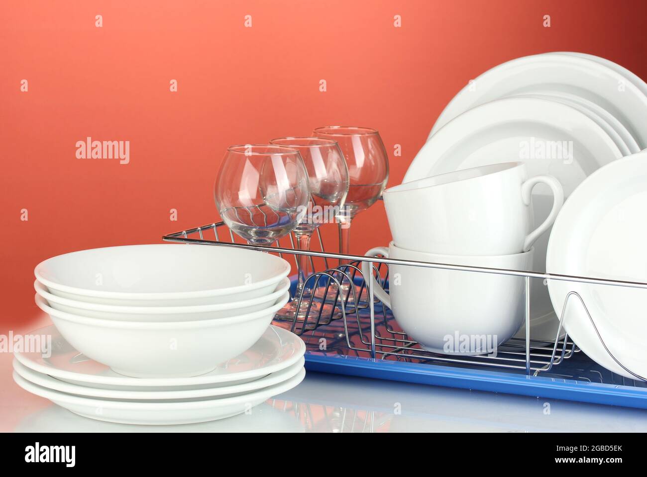 clean dishes on stand on red background Stock Photo - Alamy