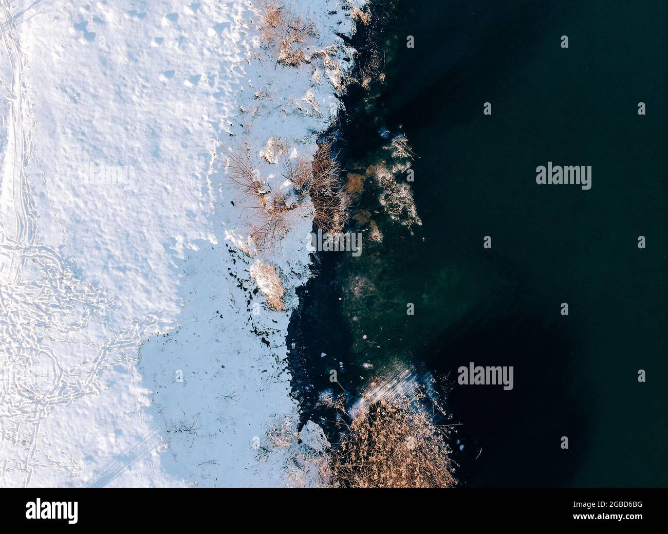 Aerial view of a lake near the land covered in deep snow Stock Photo ...
