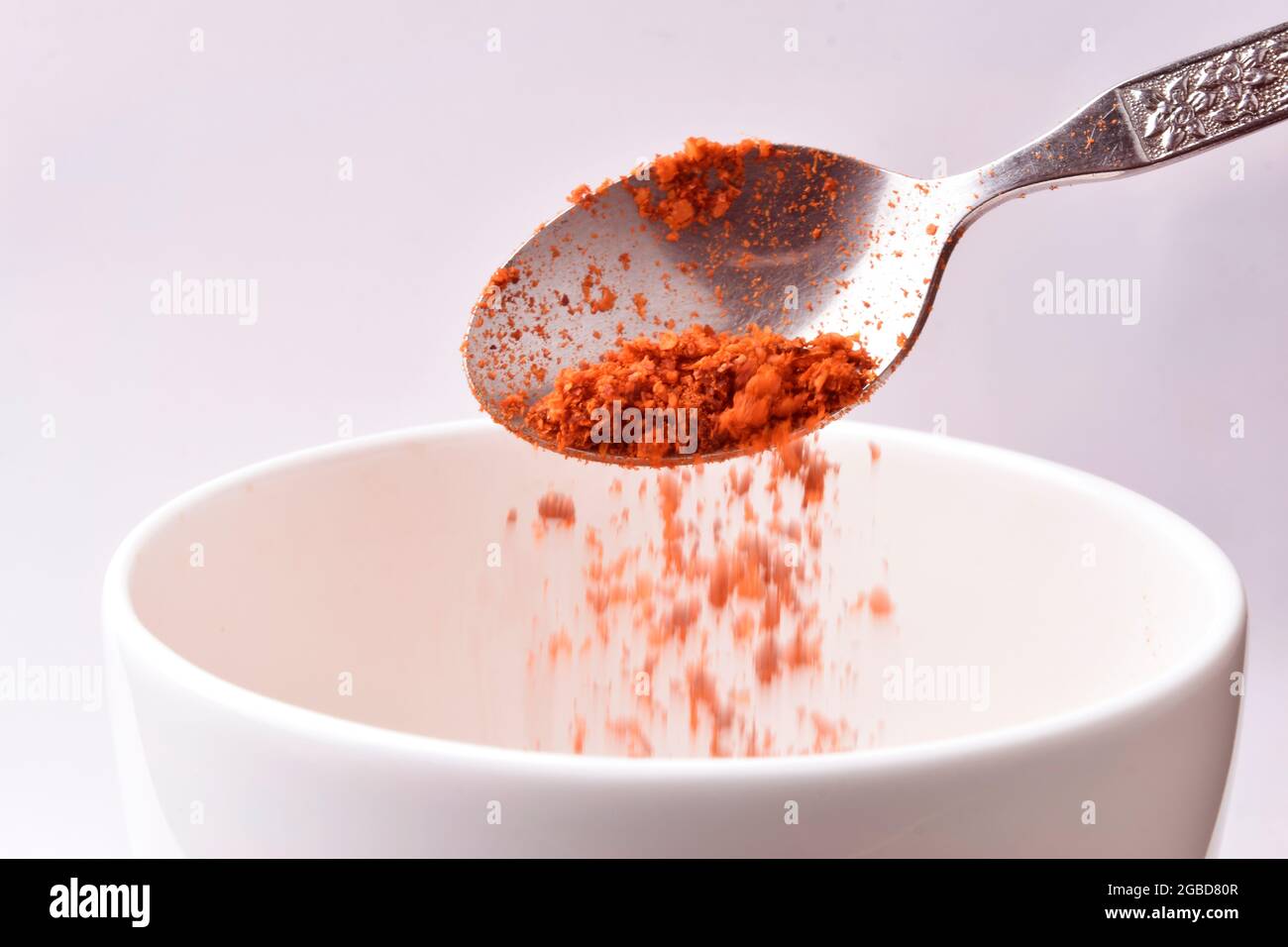 steel Spoon of red chili powder in white bowl isolated on white ...