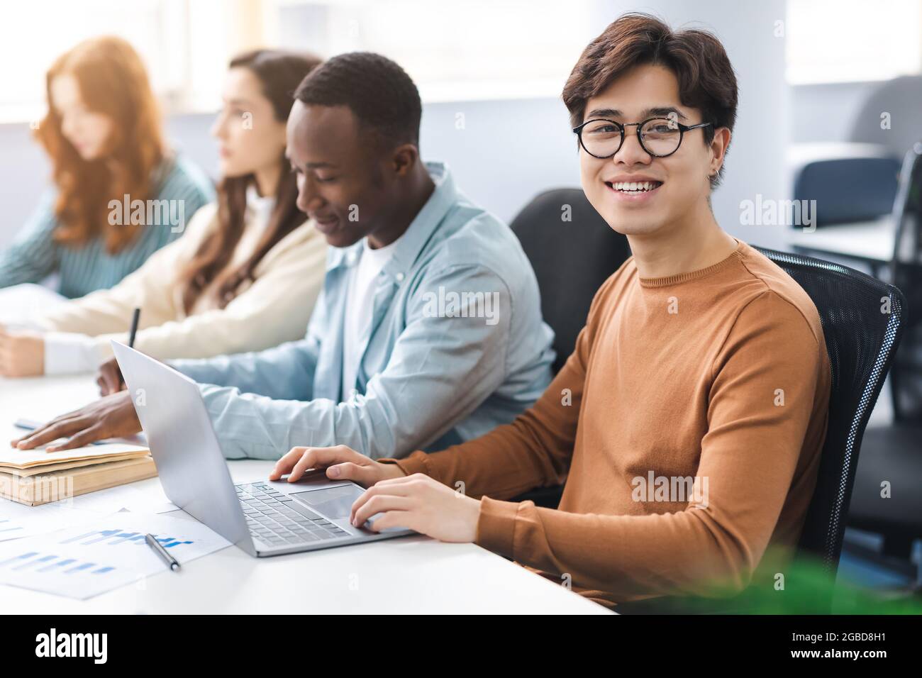 Group of international people using laptops in public library Stock ...