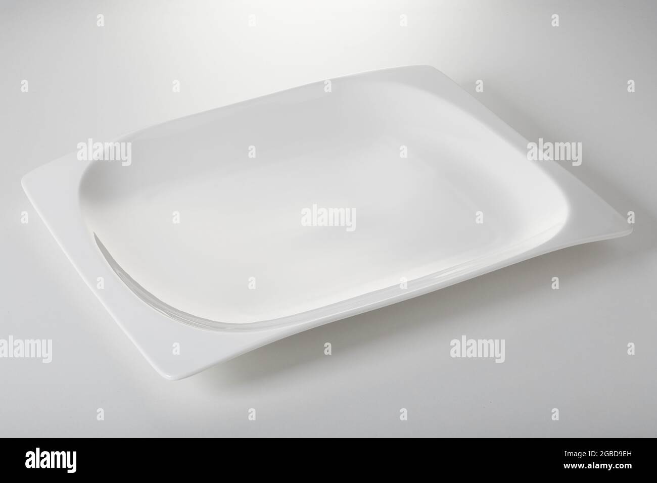 High angle of empty clean rectangle plate placed on white background in ...