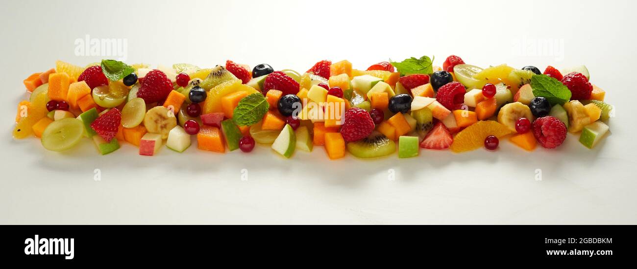 From above of chopped ripe fruits and berries placed in row on white ...