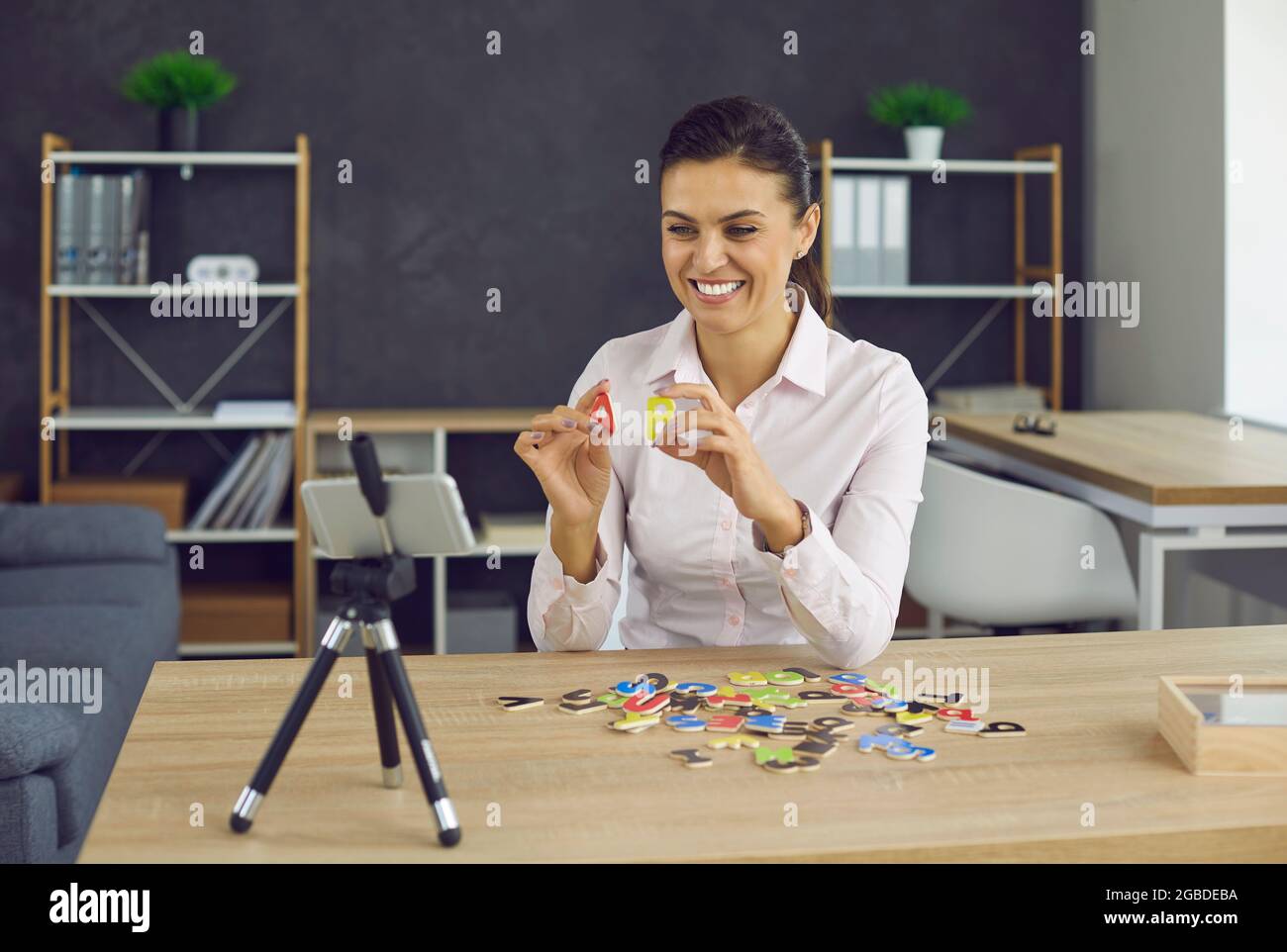 Young teacher woman conducts distance learning for small children ...