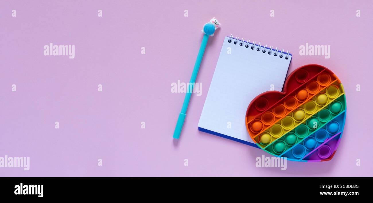 Back to school concept.Notepad, blue pen and antistress toy in the form ...