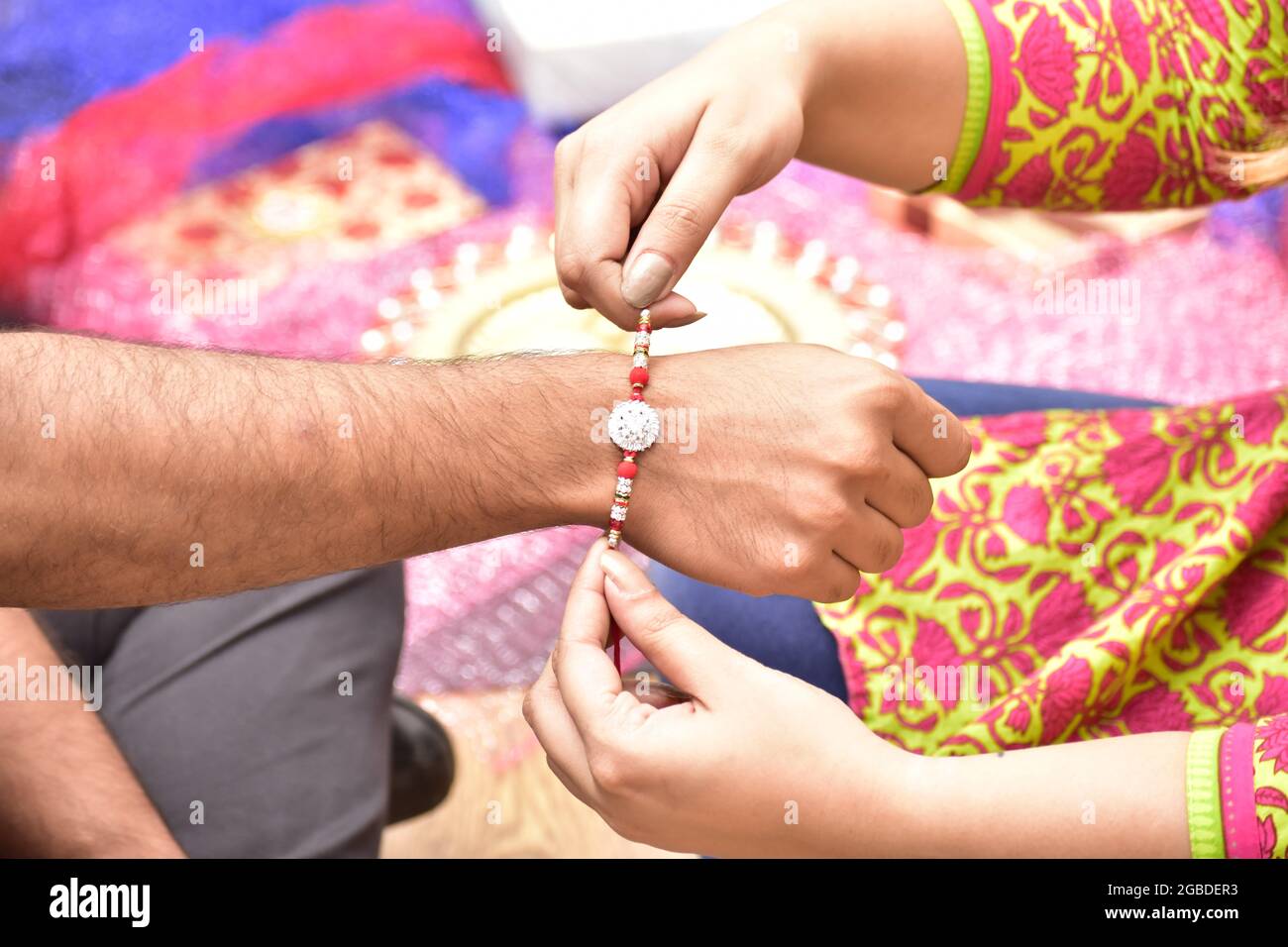 Sister tie Rakhi on Brother's Hand Stock Photo - Alamy