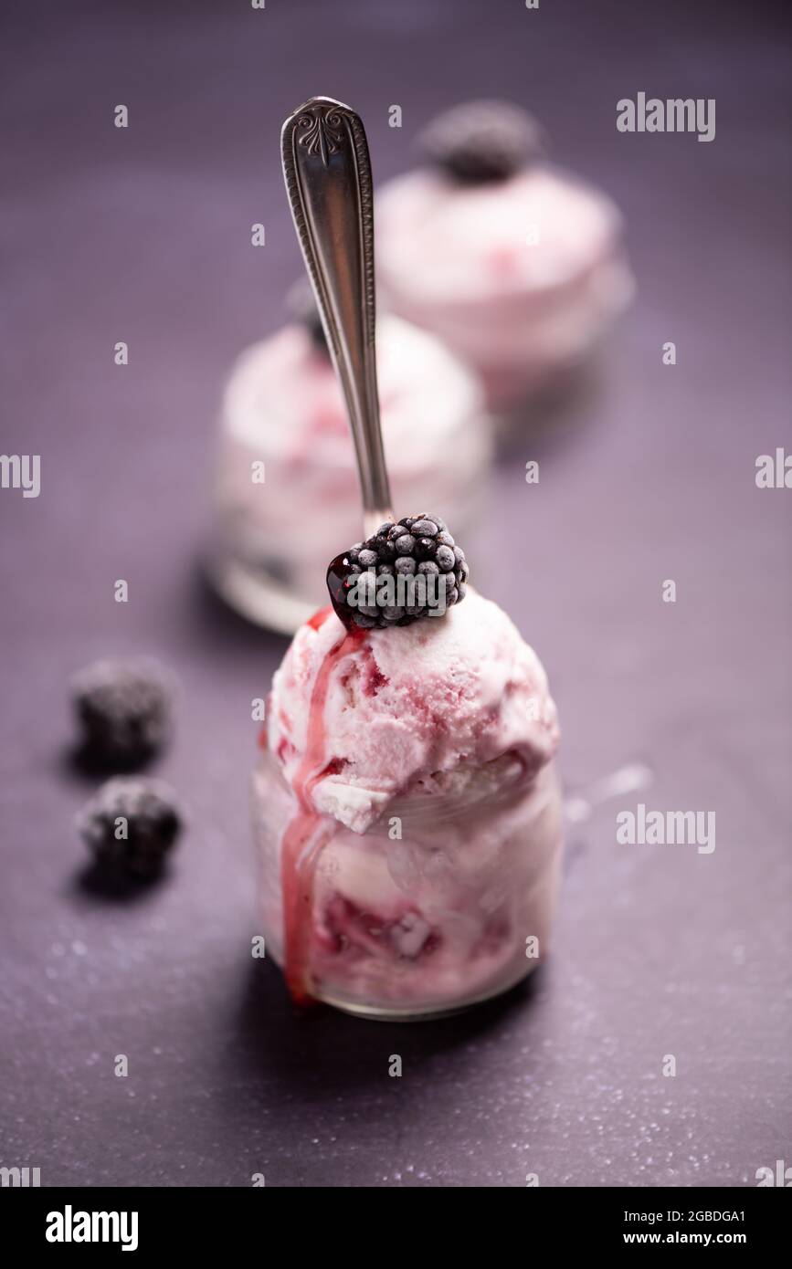 Blueberry and blackberry ice cream in bowl with frozen fruits close up ...