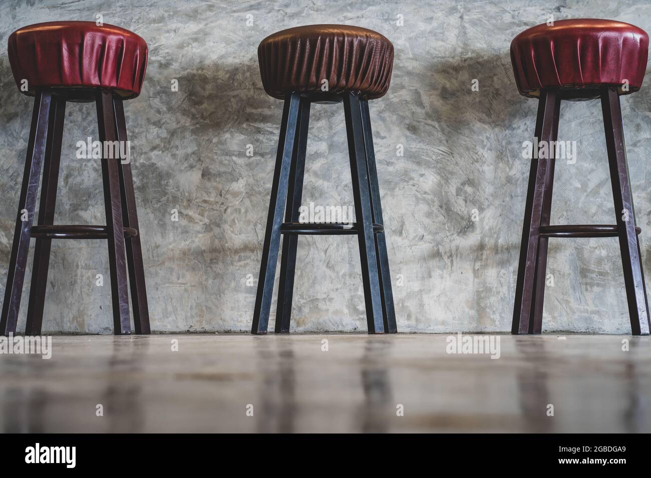 Closeup shot of three stools against a grungy wall in a cafe Stock ...