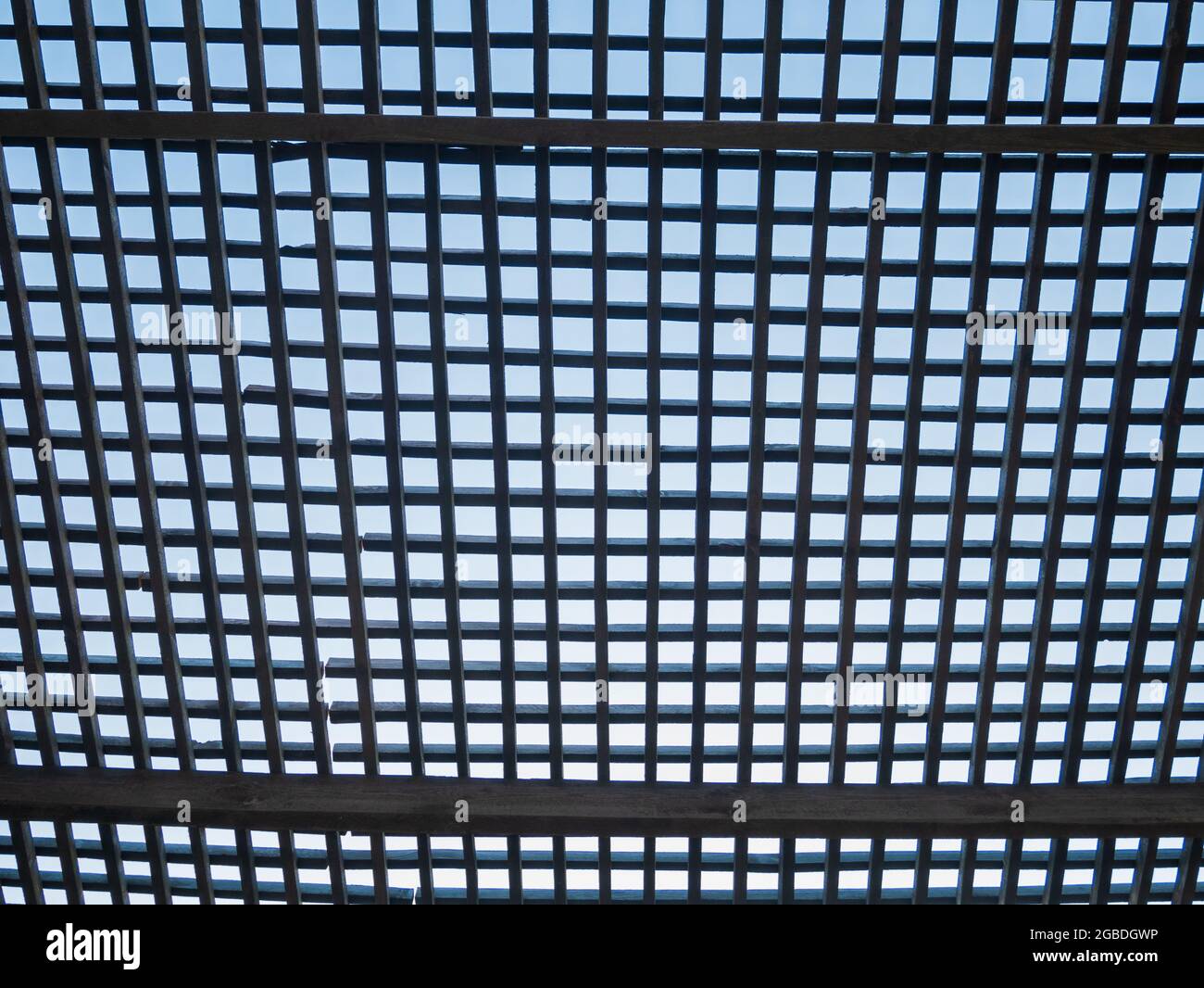 Wooden square timber lattice fence on a blue sky background. Eco wood ...