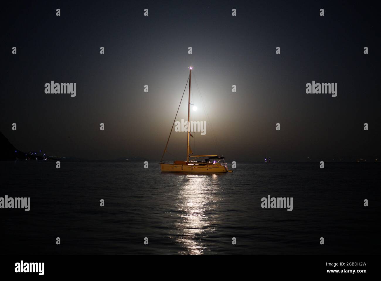 Boat under the moon, reflecting the moonlight Stock Photo - Alamy