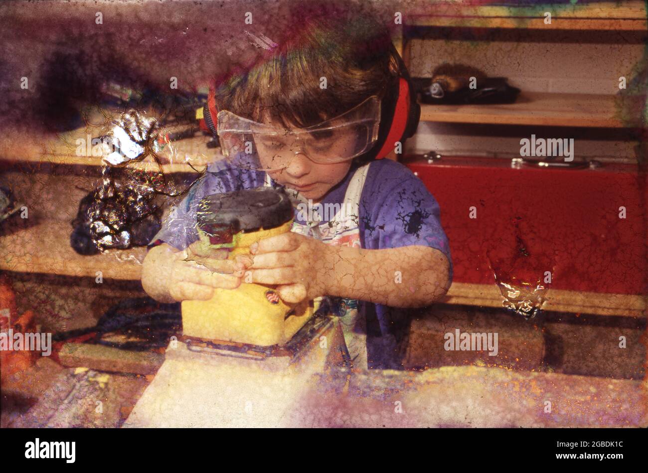©1998 Four year old boy using protection while sanding a project under ...