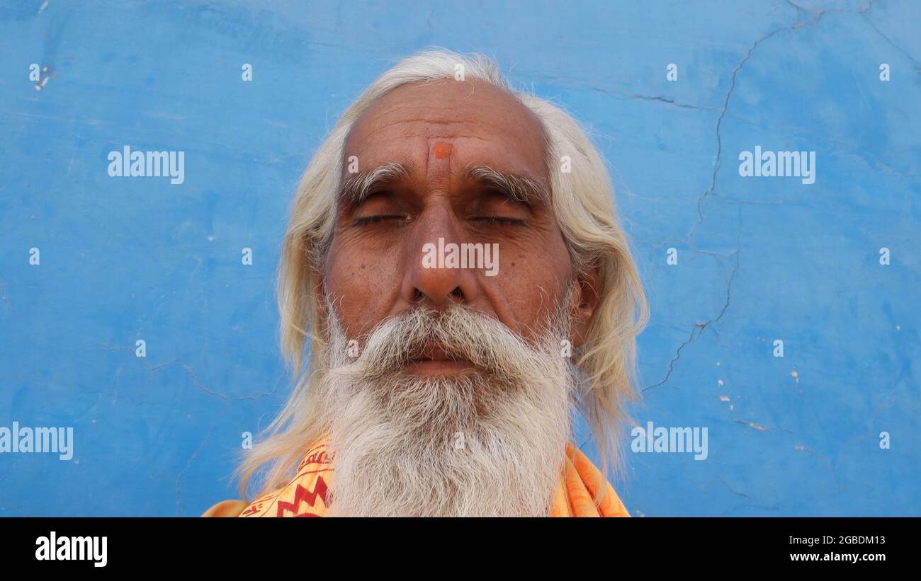 Religious ascetic Sadhu in traditional Indian clothes sitting outdoor ...