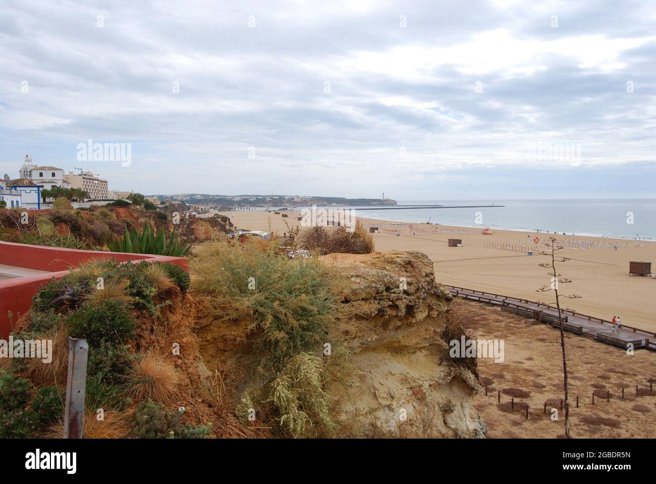 Landscape of a beach surroundwed by the sea and cottages under a cloudy ...