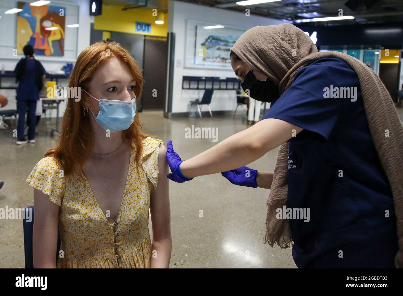 A NHS health worker administers a dose of Pfizer Covid-19 vaccine to ...