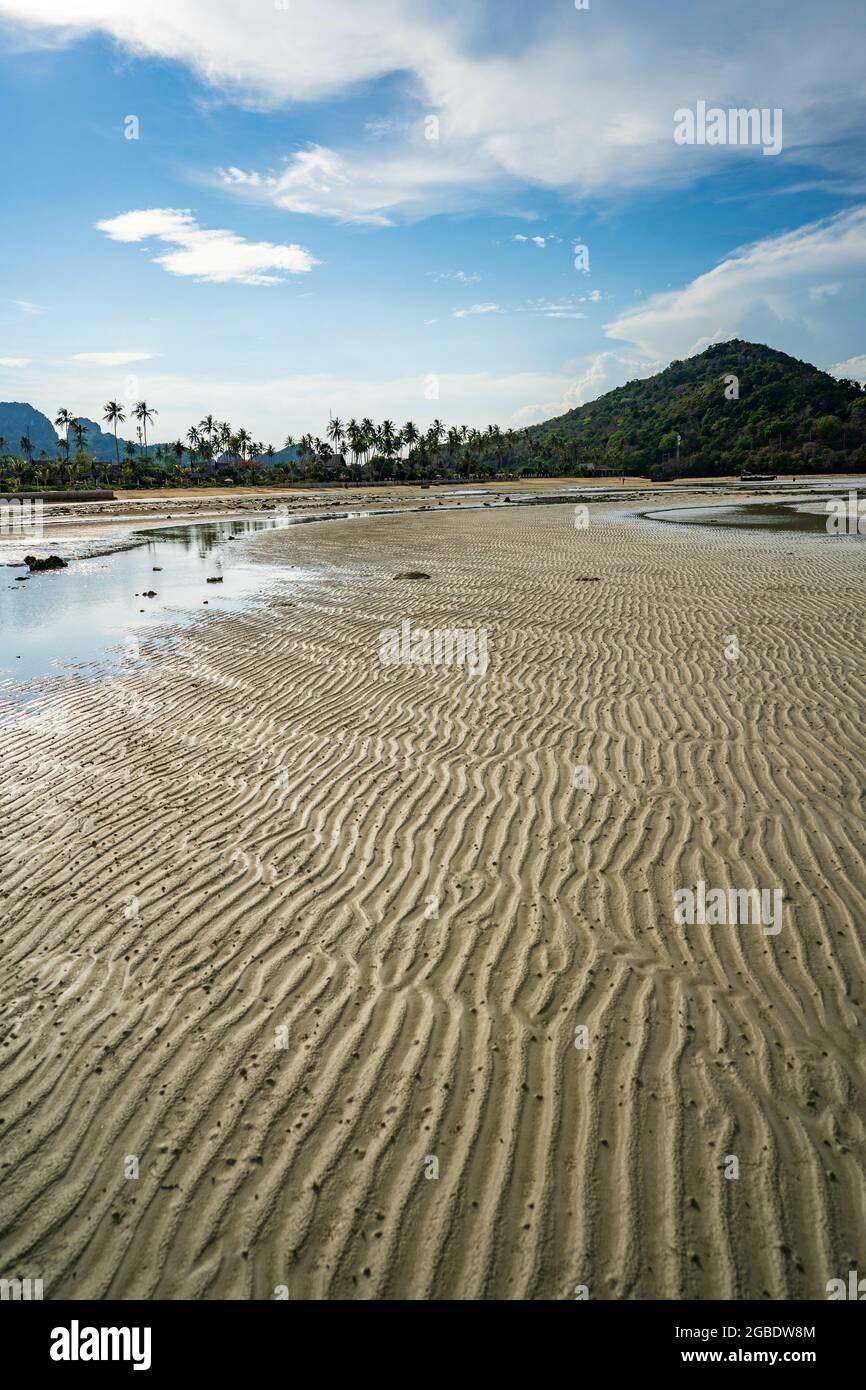 Beautiful view of beach sand near the water with green mountain and ...