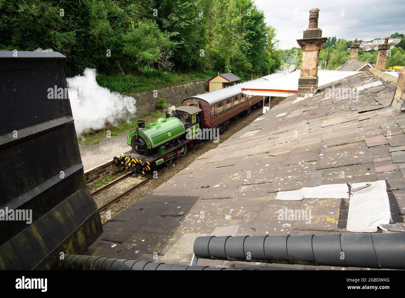 Small green steam train in a railway station Stock Photo - Alamy