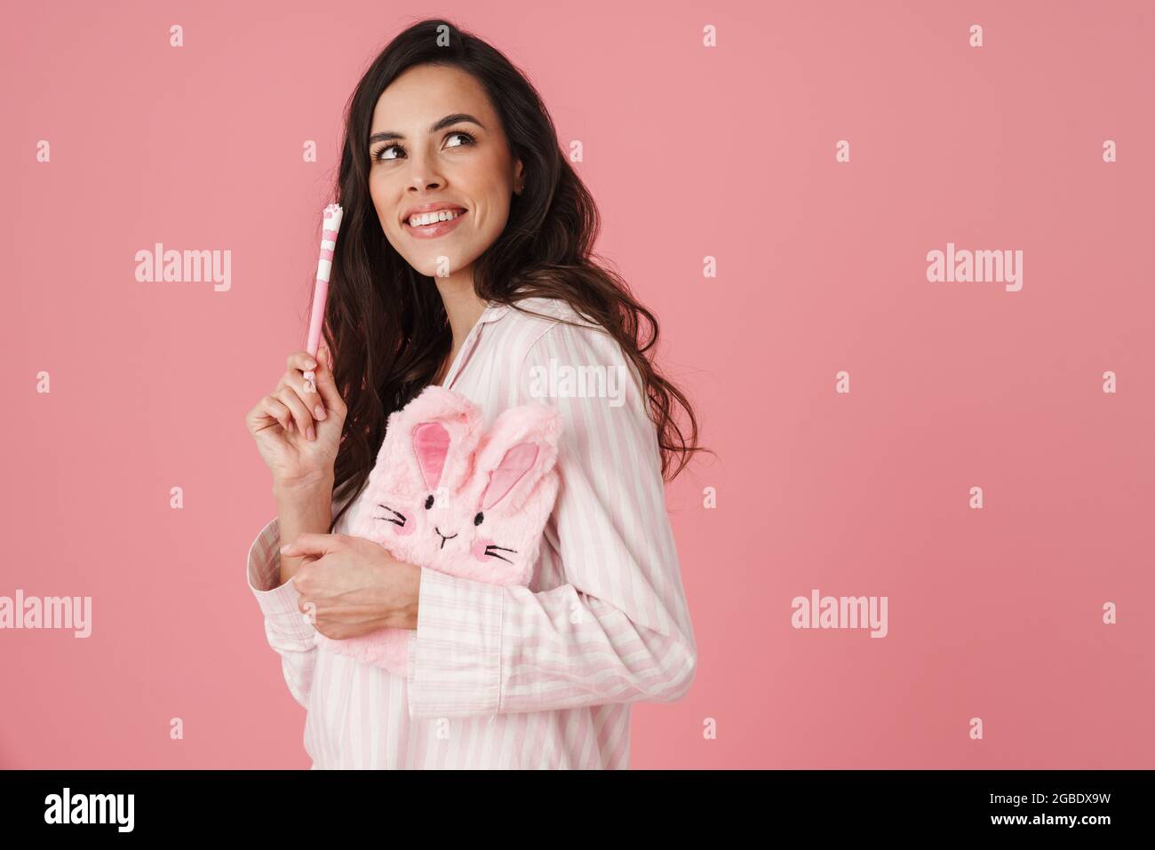 Happy beautiful woman in pajama posing with pen and bunny diary ...