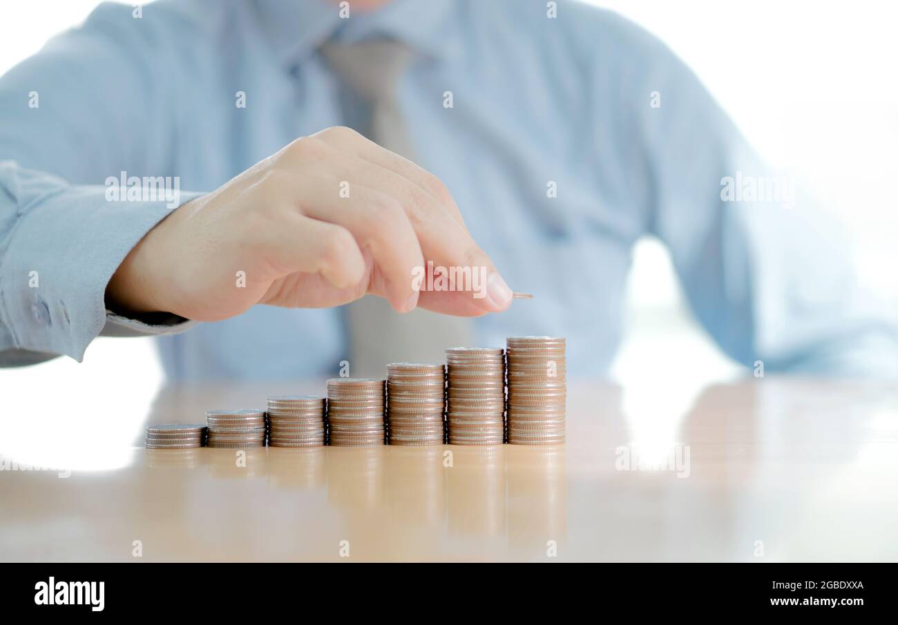 Businessman putting coins hi-res stock photography and images - Alamy
