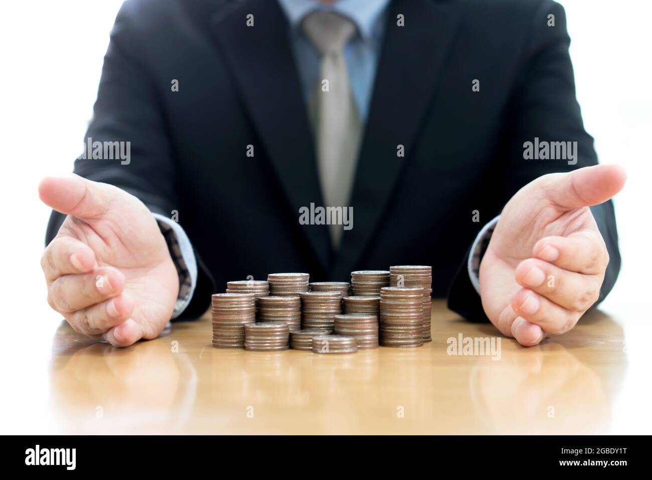 Businessman Protect Stack Of Coins Stock Photo - Alamy